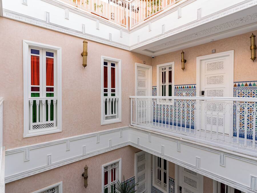 Um edifício com vários níveis, varandas, portas ornamentadas e azulejos estampados.