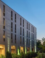Um edifício moderno com fachada de tijolos e várias janelas.