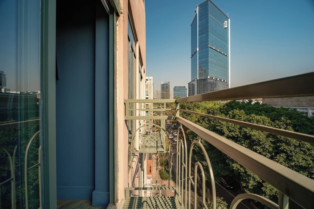 Varanda com vista para a paisagem urbana, incluindo edifícios altos e áreas verdes.