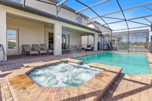 Piscina descoberta coberta com hidromassagem, espreguiçadeiras e área de terraço.