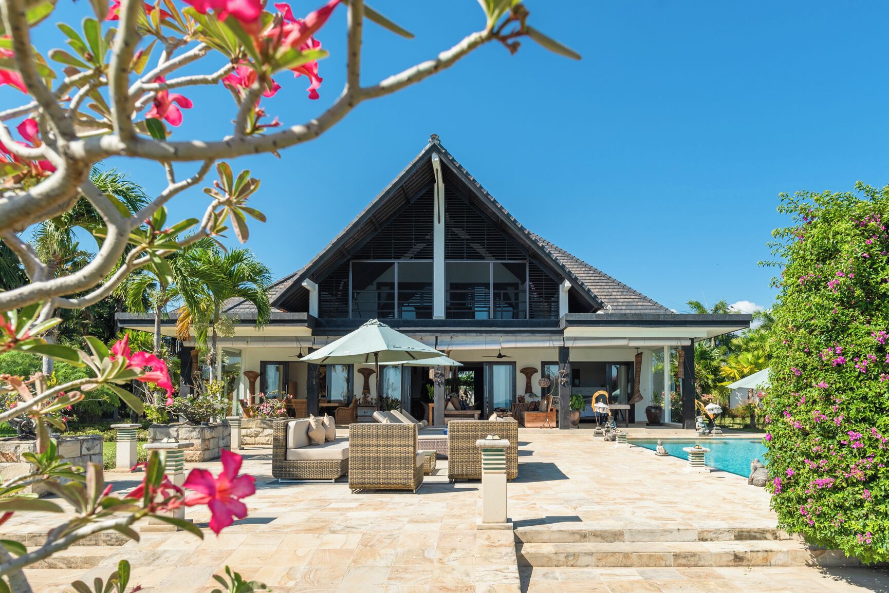 Uma casa moderna com uma varanda grande, área de estar externa e piscina.