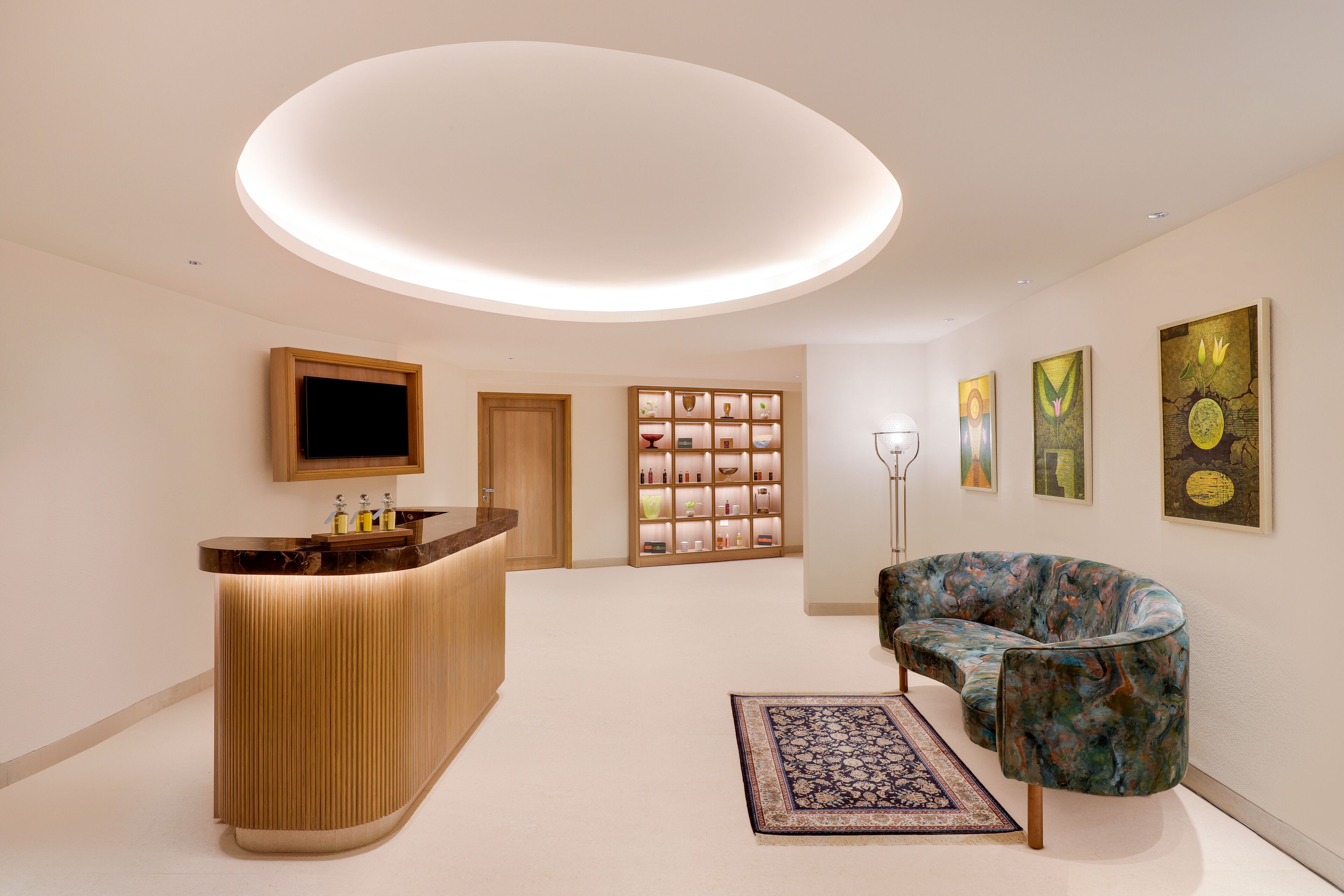 Um lobby moderno com uma receção, área de estar, estante de livros e obras de arte nas paredes.