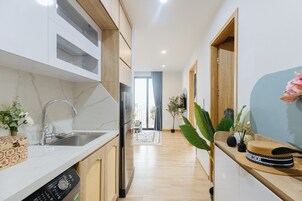 Uma cozinha moderna com uma pia de aço inoxidável, armários de madeira e um forno embutido.