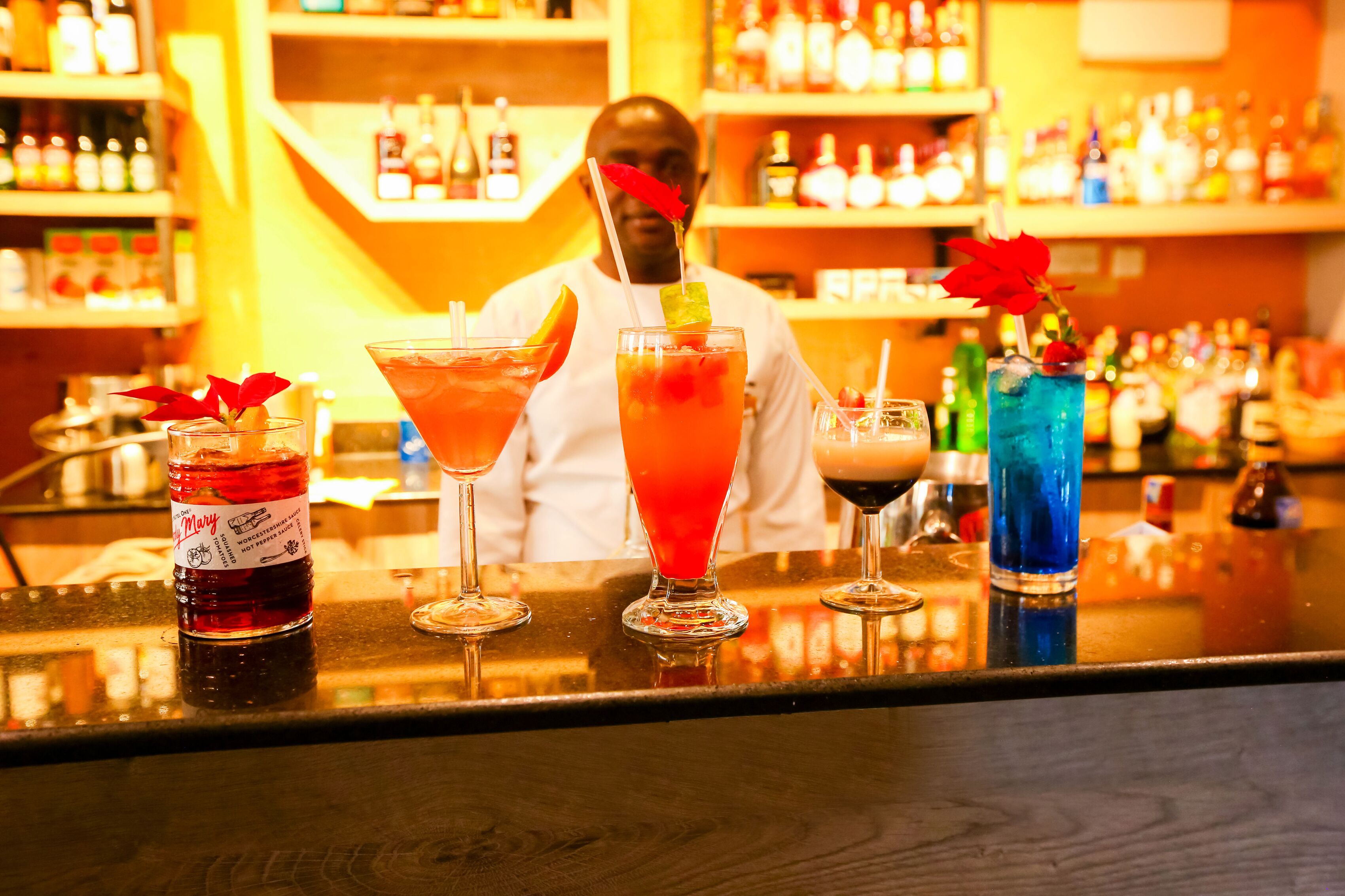 Uma área de bar com diversos drinques e garrafas.