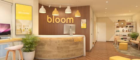 Uma área de recepção moderna com um balcão de madeira, um letreiro grande com a palavra 'bloom' e um piso em padrão herringbone.