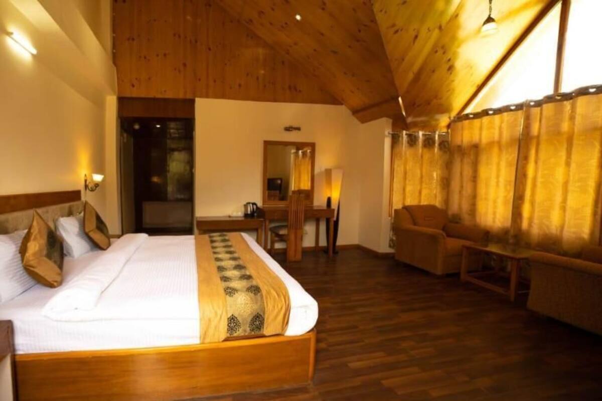 Quarto com cama de madeira, escrivaninha, cadeira e espelho.