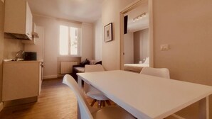 Um espaço compacto com cozinha compacta, área de refeições e cama.