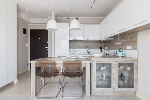 Uma máquina de lavar louça, uma cafeteira/bule, utensílios de cozinha 