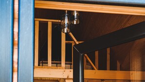 Interior em madeira com escada, janela e porta que dá para outro quarto.