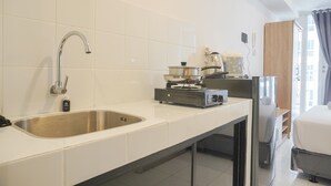 Uma cozinha moderna com uma pia de aço inoxidável, fogão a gás e geladeira.