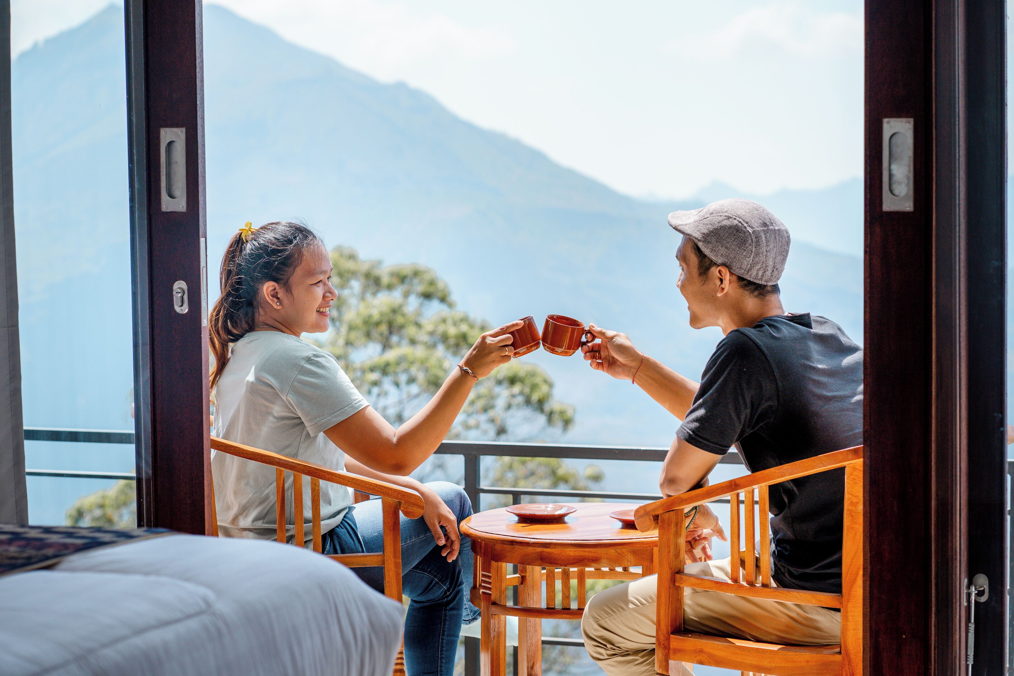 Duas pessoas sentadas numa mesa de madeira com vista para a montanha.