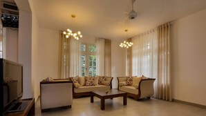 Uma sala de estar com sofá, mesa de centro e televisão.
