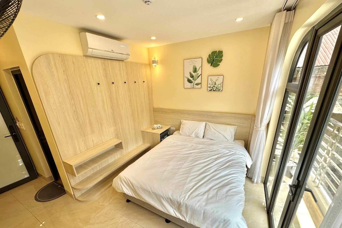 Quarto com cama, penteadeira e área de chuveiro.
