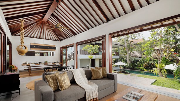 Uma sala de estar moderna com sofá, mesa de centro e área de jantar.