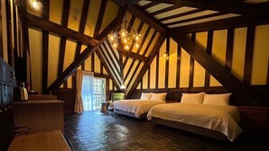 Quarto com duas camas, teto de madeira e chão de pedra.