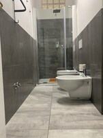 Quarto Duplo Design | Casa de banho | Um polibã, um chuveiro fixo, artigos de higiene pessoal grátis 