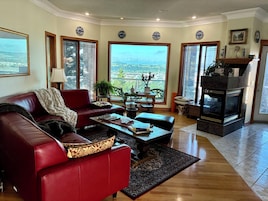 Uma sala de estar com um sofá vermelho, uma mesa de centro e uma lareira.