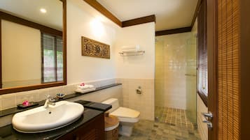 Casa de banho com lavatório branco, sanita e cabine de duche com portas de vidro.