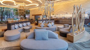 Uma área de estar moderna com assentos curvos, um bar e uma luminária decorativa.