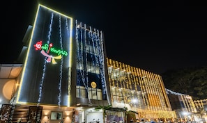 Um edifício com faixas verticais de luz e uma placa com texto.