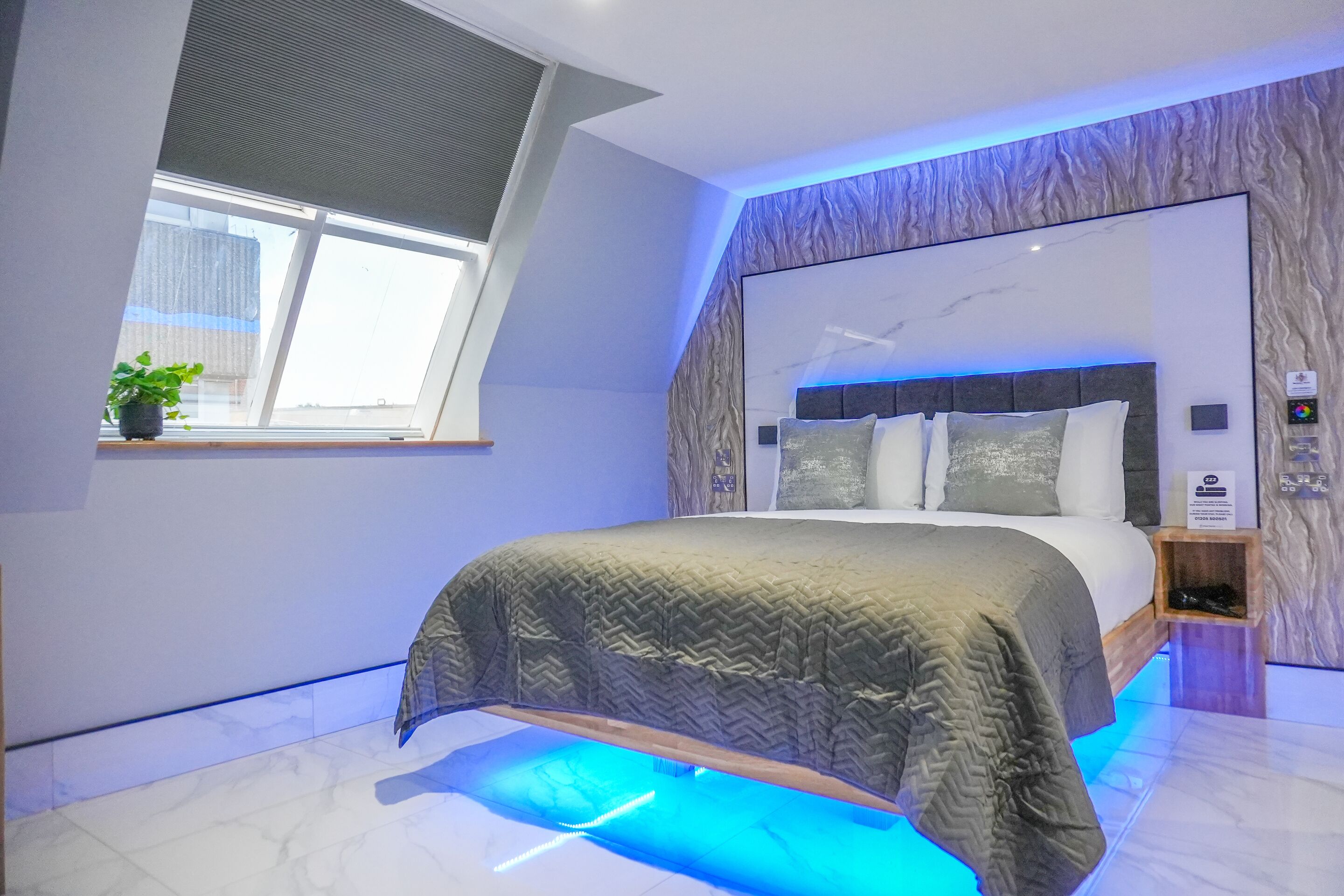 Quarto moderno com uma cama grande, janela com vista e piso de mármore.