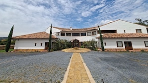 Um edifício grande e branco, com telhado telhado e entrada central.