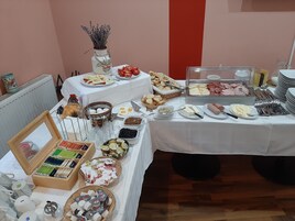 Mesa de buffet com diversos alimentos e utensílios.