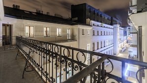 Vista noturna de um edifício com varandas e escadaria.