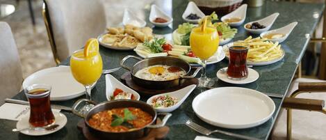 Uma mesa de jantar posta com diversos pratos, incluindo uma travessa de comida, pratos de comida e bebidas.