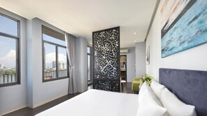 Quarto de hotel moderno com uma cama grande, divisória decorativa e vista para a cidade.