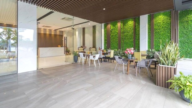 Um interior moderno com teto de madeira, parede verde e balcão de recepção.