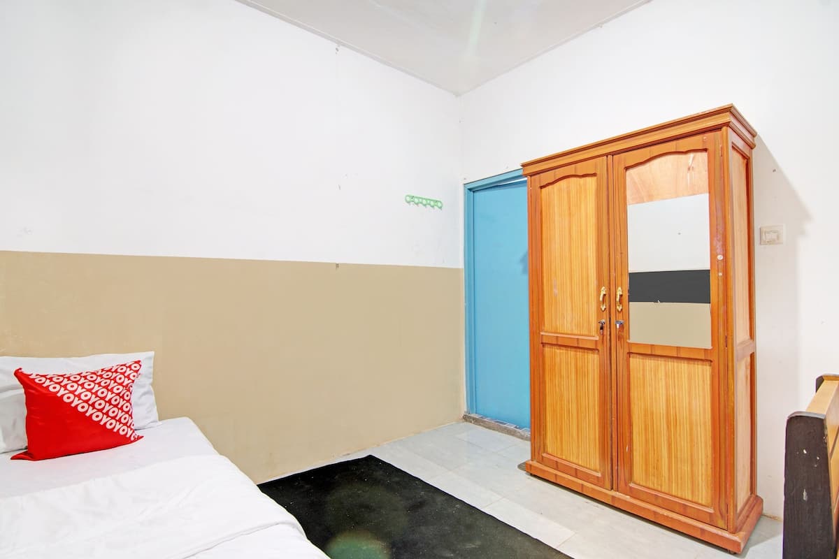Quarto com cama, guarda-roupa e porta azul.