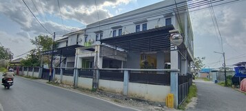 Um edifício de vários andares com varanda e um espelho grande.
