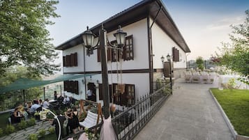 Edifício de dois andares com varanda e área de estar ao ar livre.