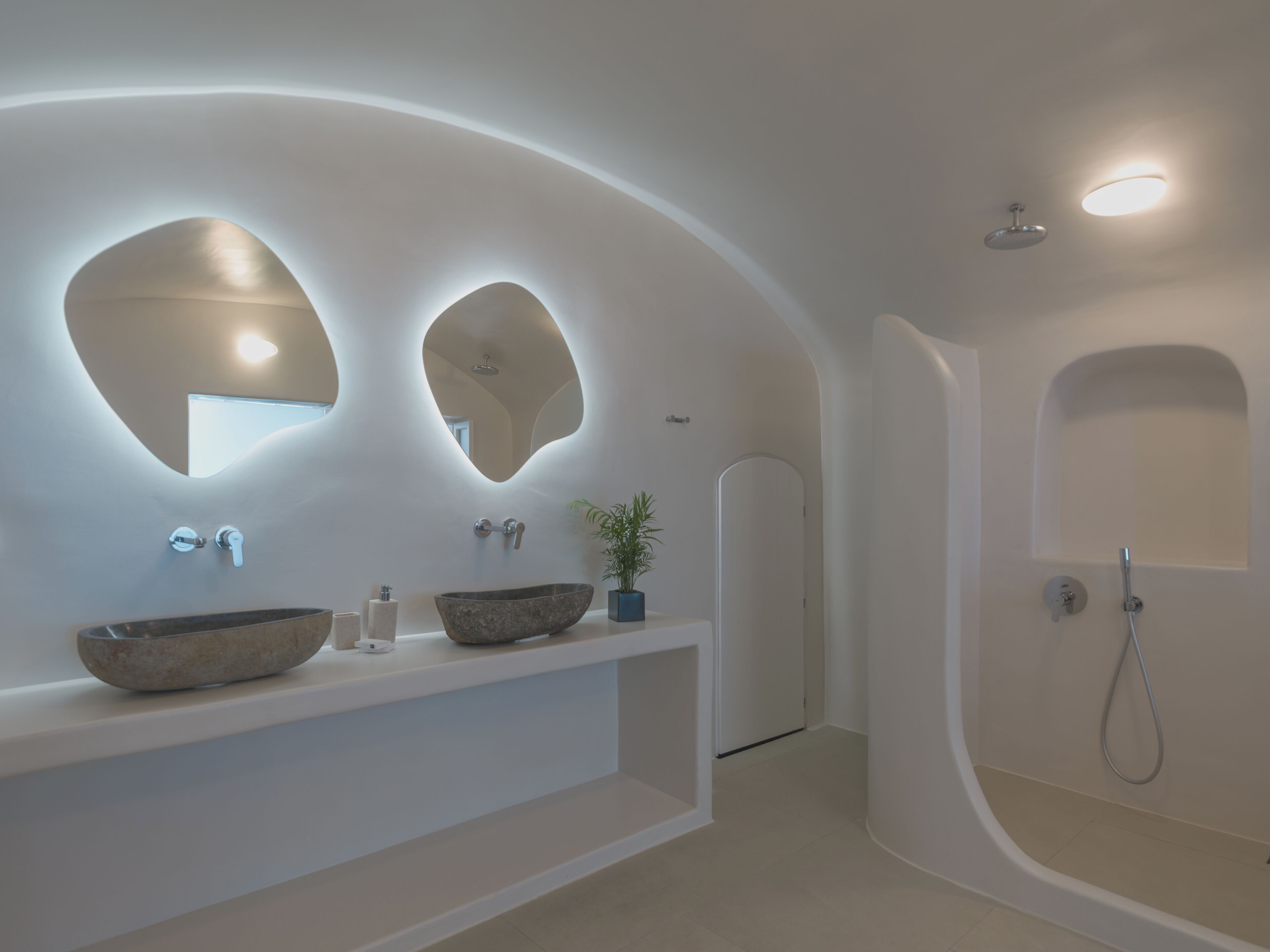 Uma casa de banho moderna com um design curvo único, uma bacia grande e uma área de duche separada.