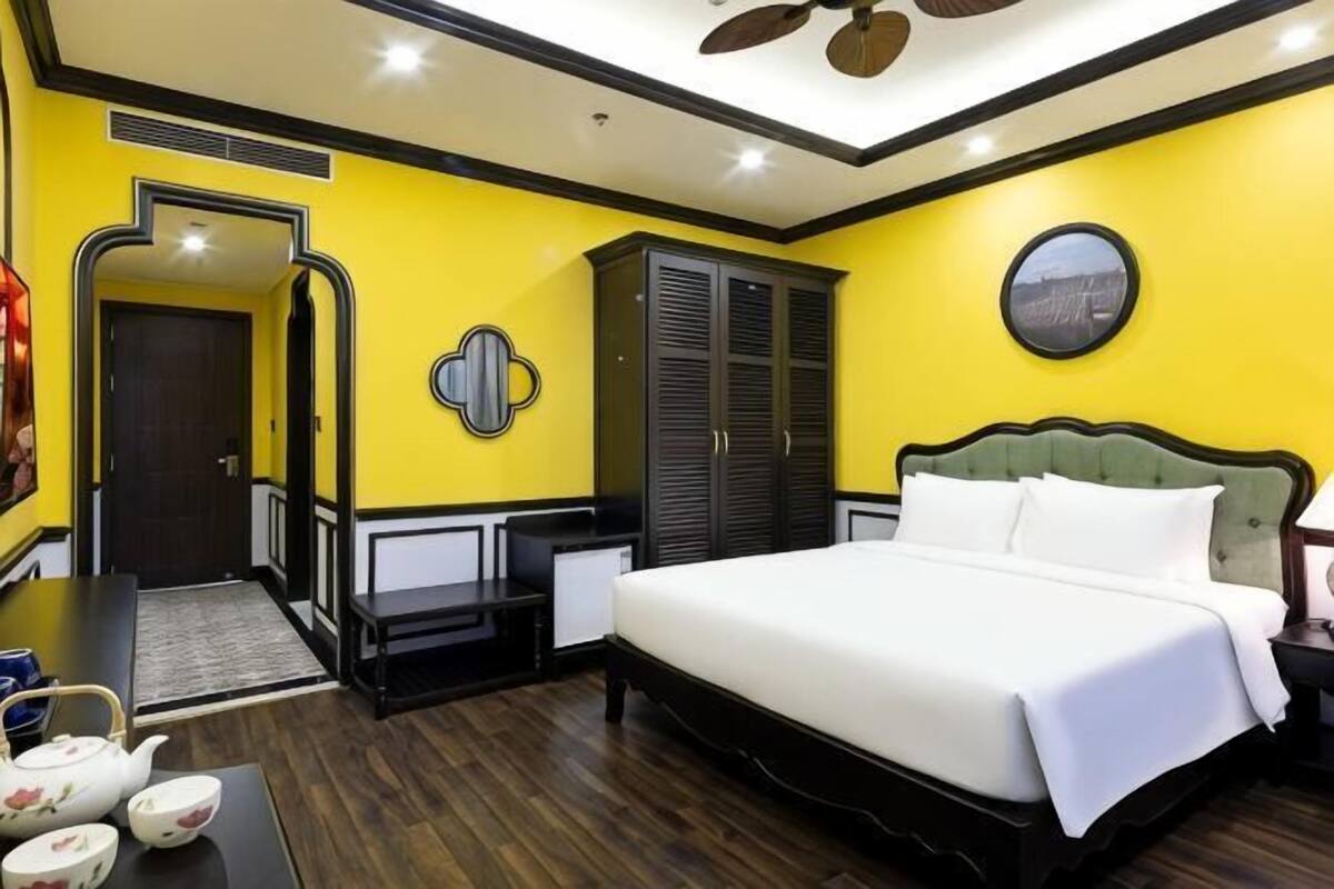 Quarto com cama, guarda-roupa, mesa de cabeceira e espelho.