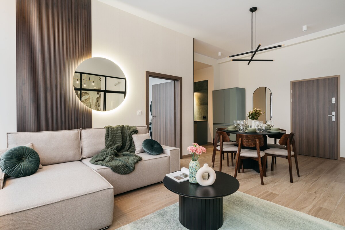 Uma sala de estar moderna com sofá, mesa de centro e área de jantar.