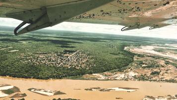 Vista aérea de um rio serpenteando por uma paisagem com vegetação densa e povoados espalhados.