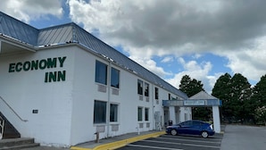 Edifício Economy Inn branco com toldo azul identificado como 