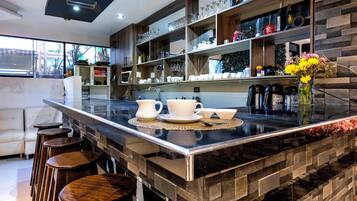 Uma cozinha moderna com ilha de mármore, banquetas e diversos utensílios de cozinha.