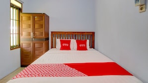 Quarto com cama, guarda-roupa e janela.