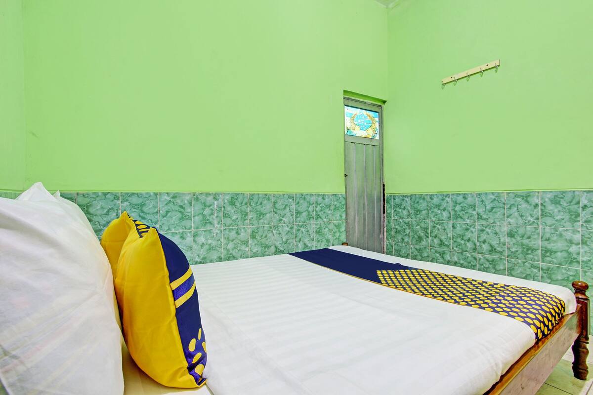 Quarto com cama, janela e porta.