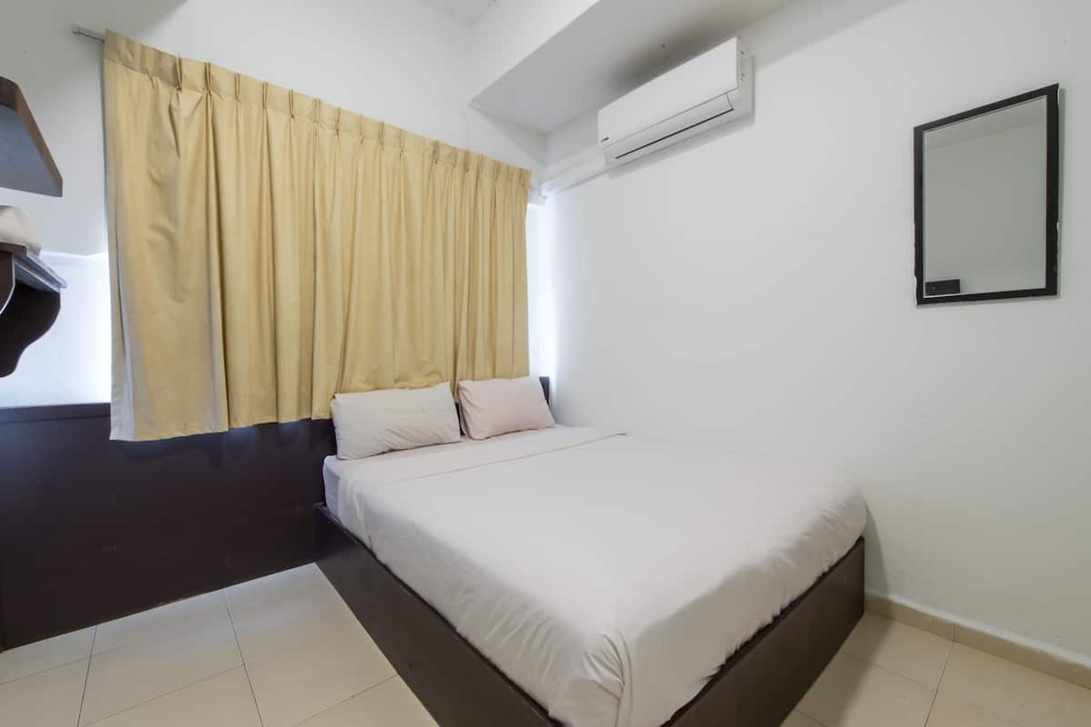 Quarto com cama, cortinas, ar condicionado e espelho.