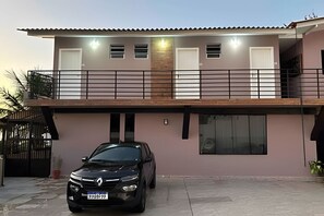 Um prédio de dois andares com um carro estacionado na frente.