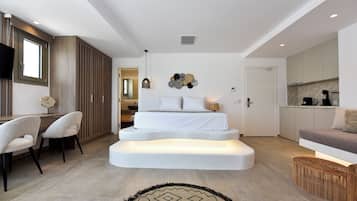 Quarto moderno com cama curva, escrivaninha e área de estar.