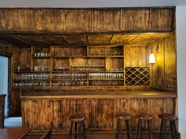 Uma área de bar com prateleiras de madeira e bancos.