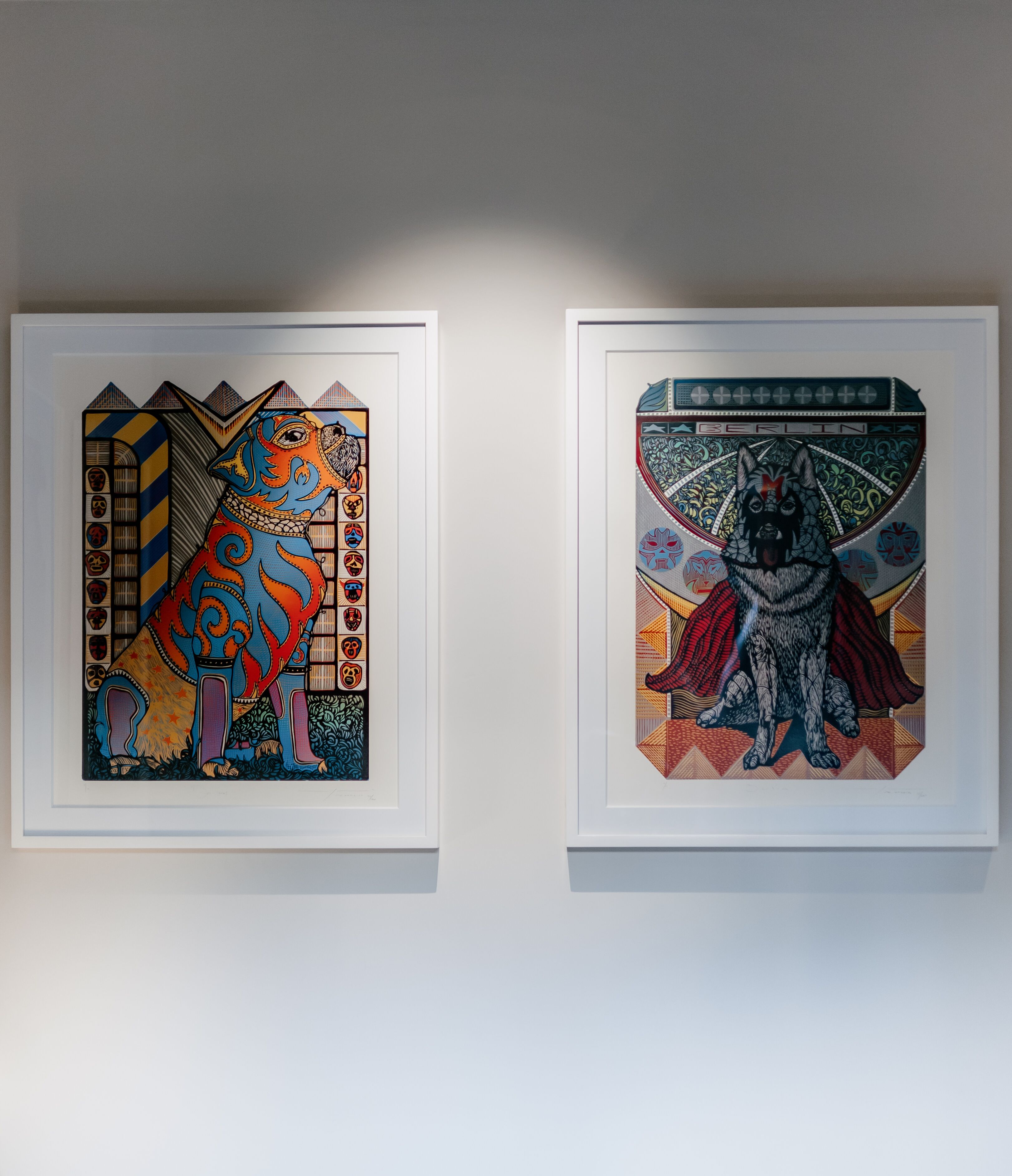 Duas obras de arte emolduradas em uma parede.