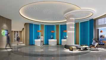 Um hall de hotel moderno com uma recepção central, áreas de estar e uma coluna grande.