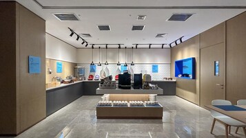Um café moderno com balcão, área de estar e vitrine de produtos.