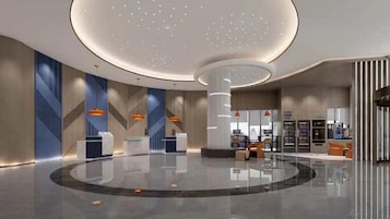 Um lobby moderno com uma recepção circular, uma coluna central e uma área de estar com vista para o interior.
